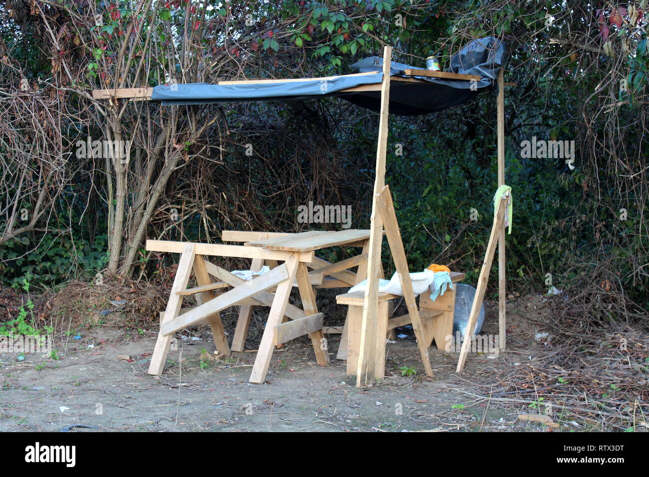 Makeshift improvised table and bench with small roof made of cerade in ...