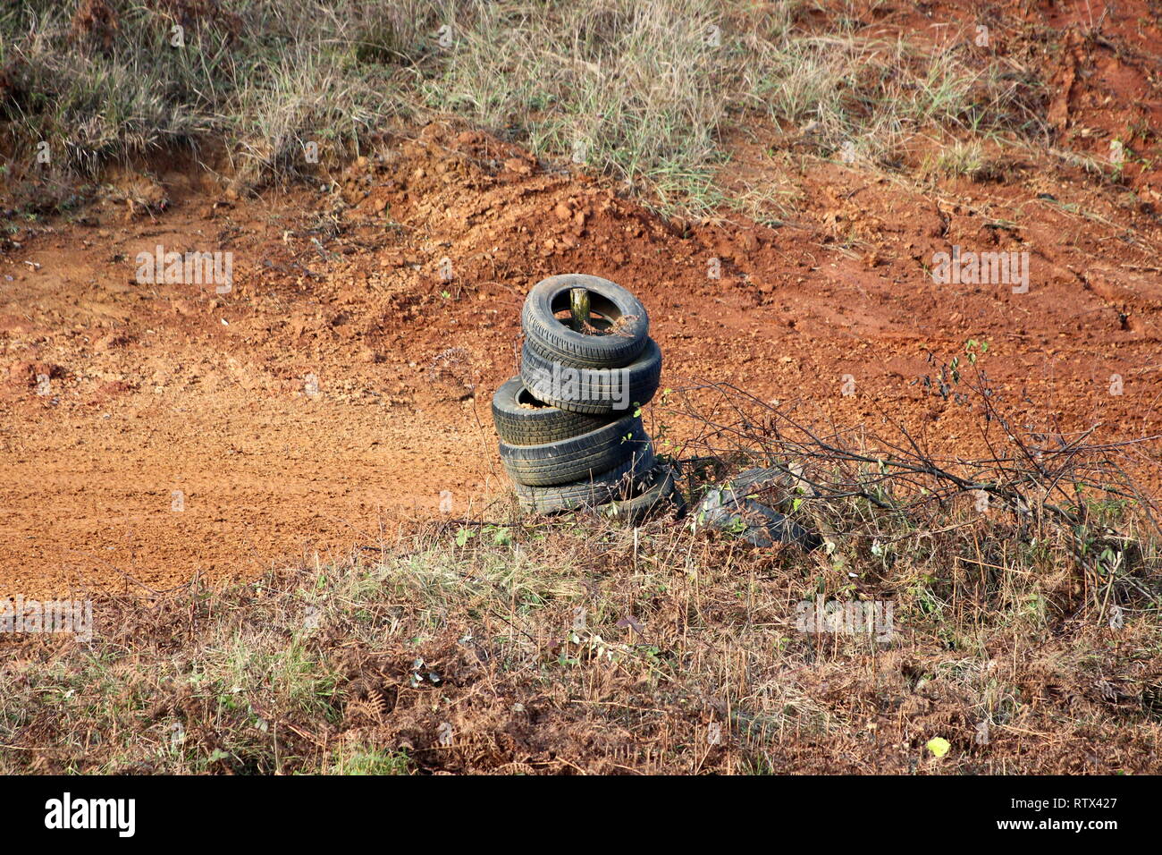 Old car tyres on single pile left on corner of local motocross racing ...