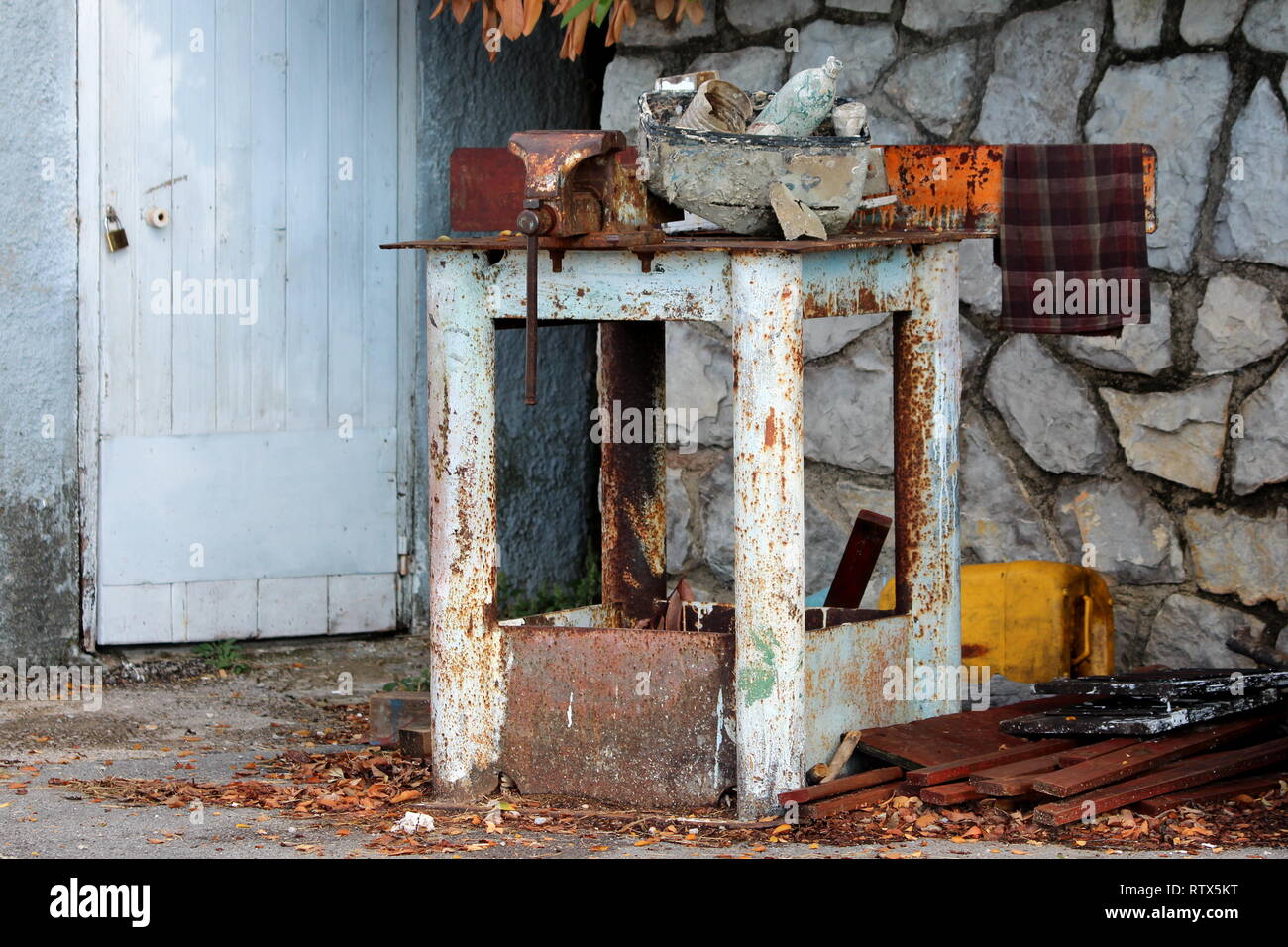 Rusted workbench vice mounted on old metal table surrounded with ...