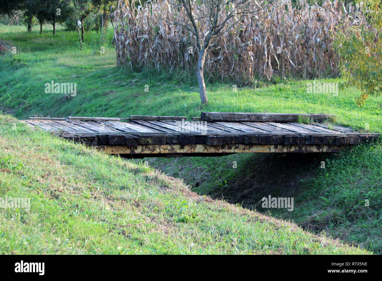 Short homemade wooden bridge with strong metal beams support connecting ...