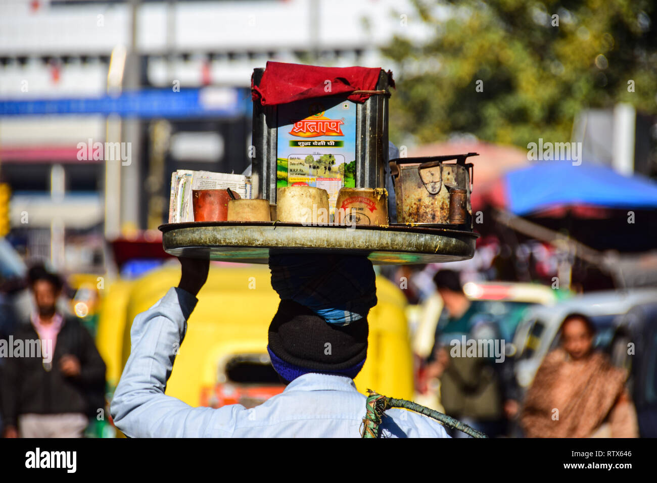 Indian Man carrying tray on his head containing Ghee, Oil, Newspaper ...