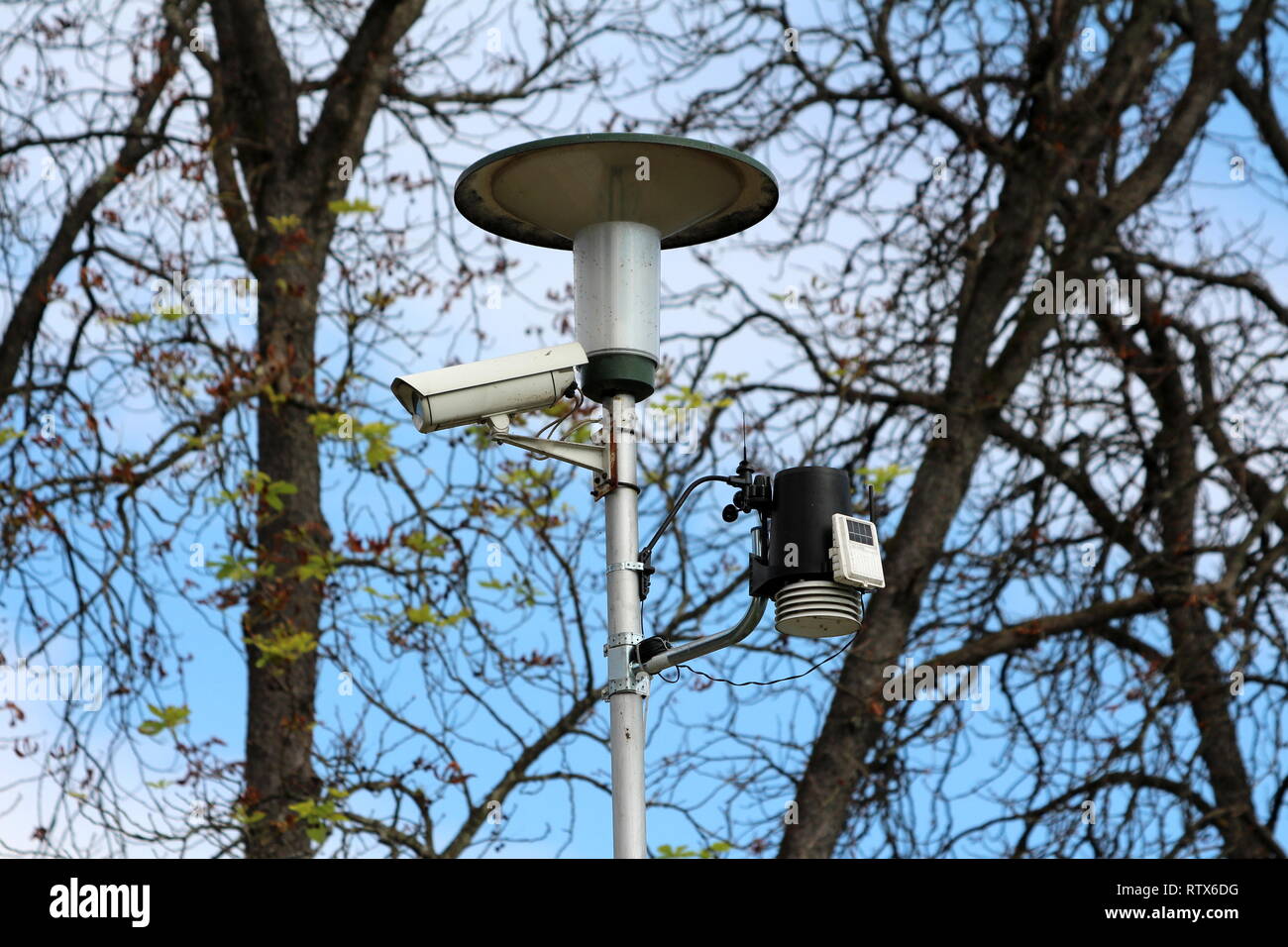 Street light on metal post with mounted surveillance camera and various ...