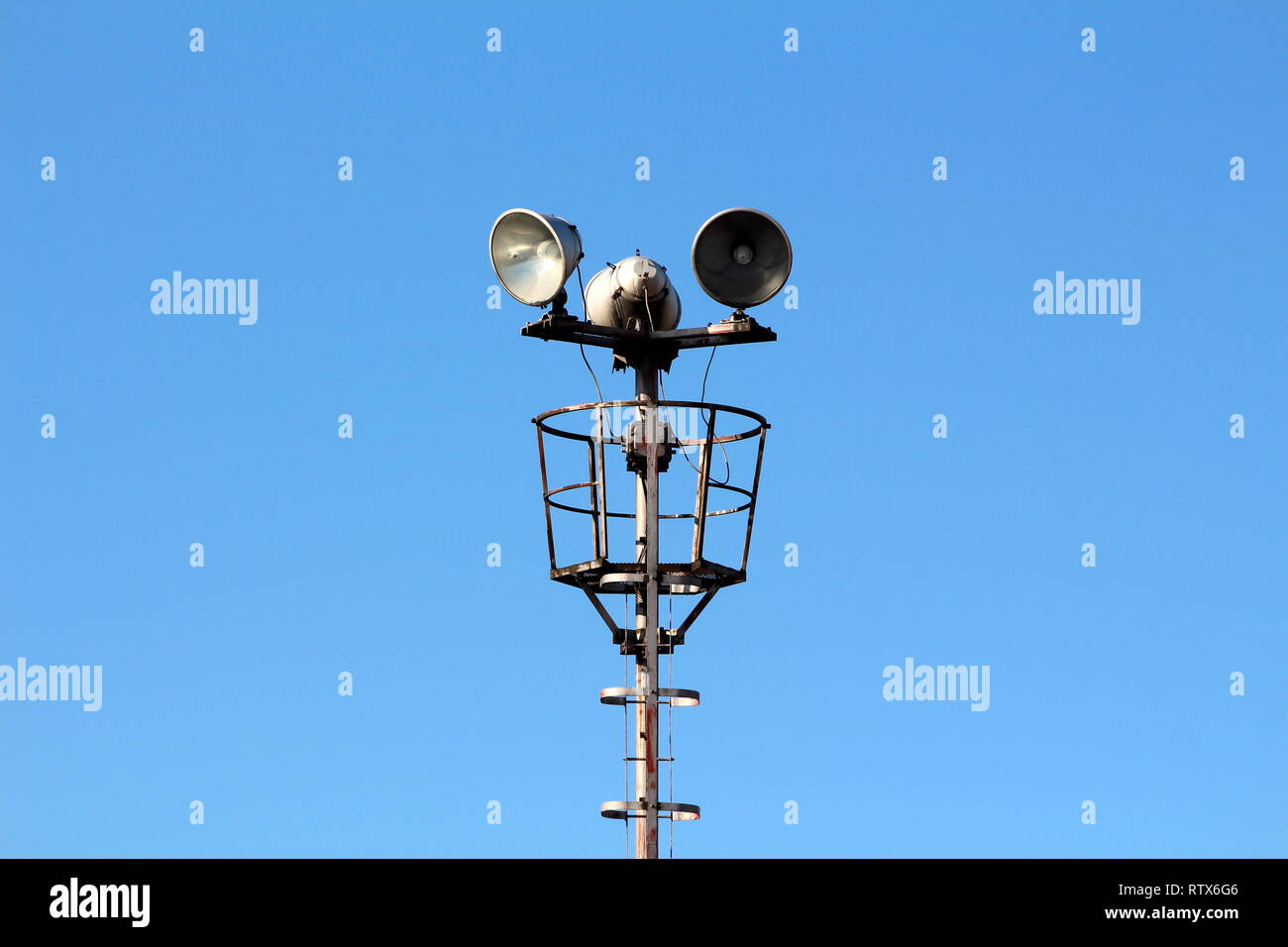 Tall metal pole with stairs leading to high; platform with three large ...