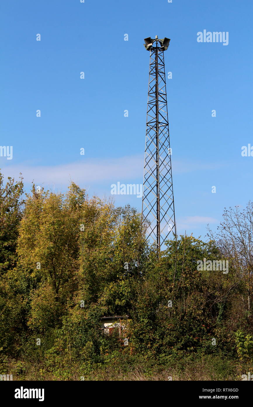 Tall metal structure holding four large public civil defence warning ...