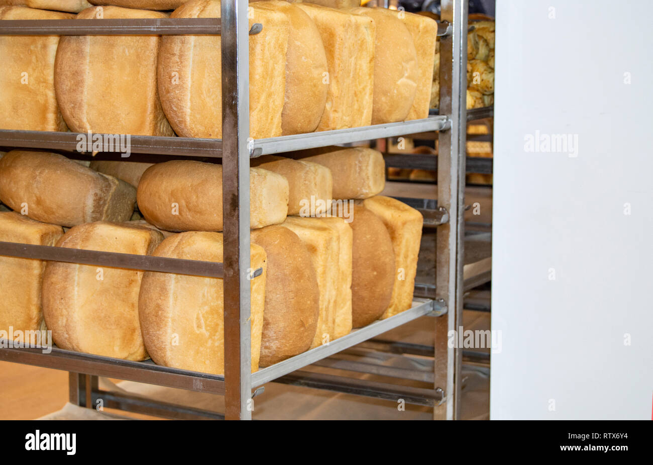 A lot of ready-made fresh bread in a mini bakery, Racks of hot bread ...