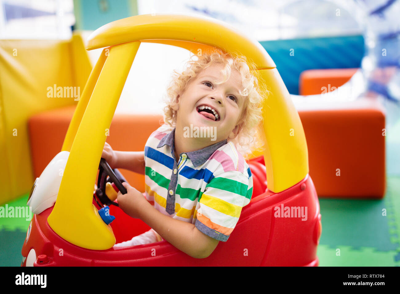 Child riding toy car. Little boy playing with big bus. Kid driving ...