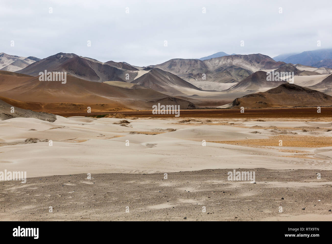 Eroded mountains, dunes and desert along the Peruvian coast north of ...