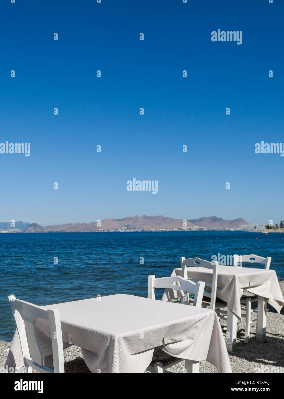 White restaurant tables on the beach in summer - travel, vacation and ...