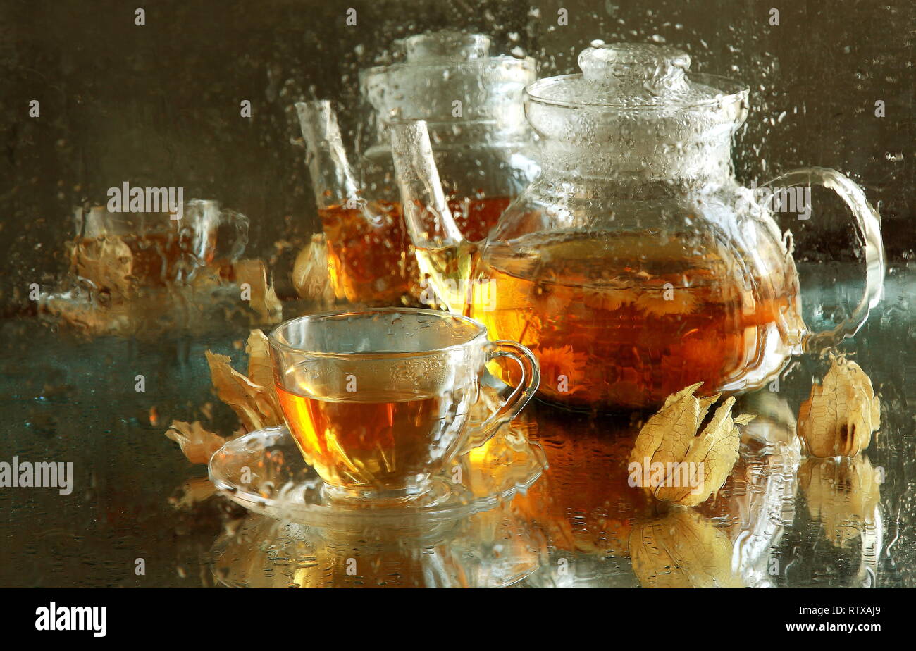 Tea in a glass teapot behind wet glass Stock Photo - Alamy