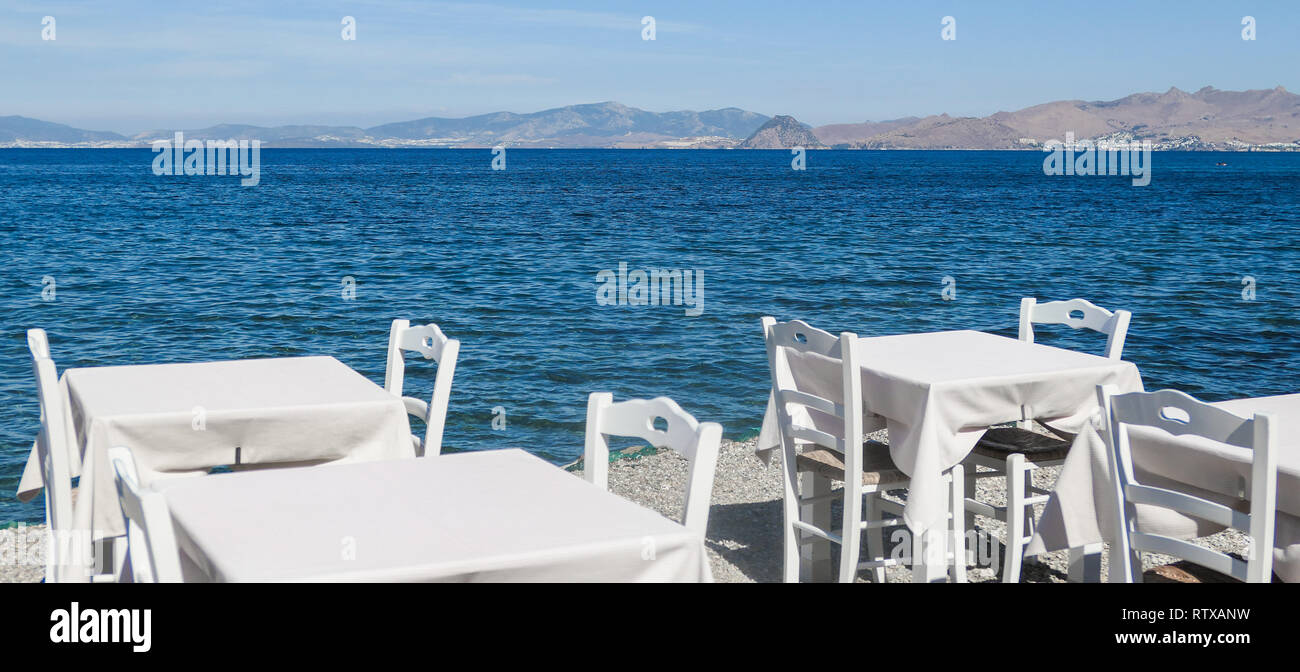 White restaurant tables on the beach in summer - travel, vacation and ...