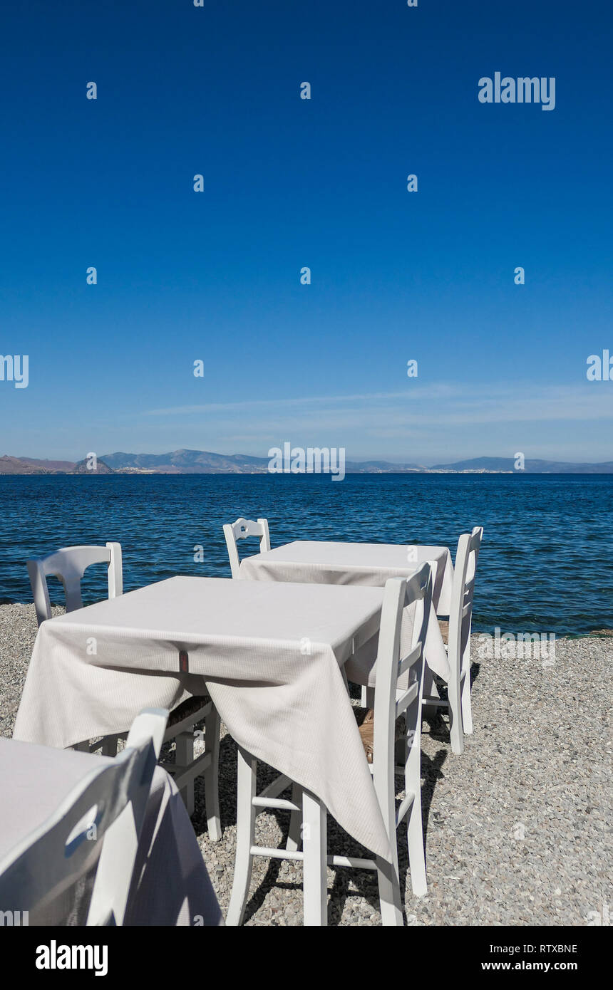 White restaurant tables on the beach in summer - travel, vacation and ...
