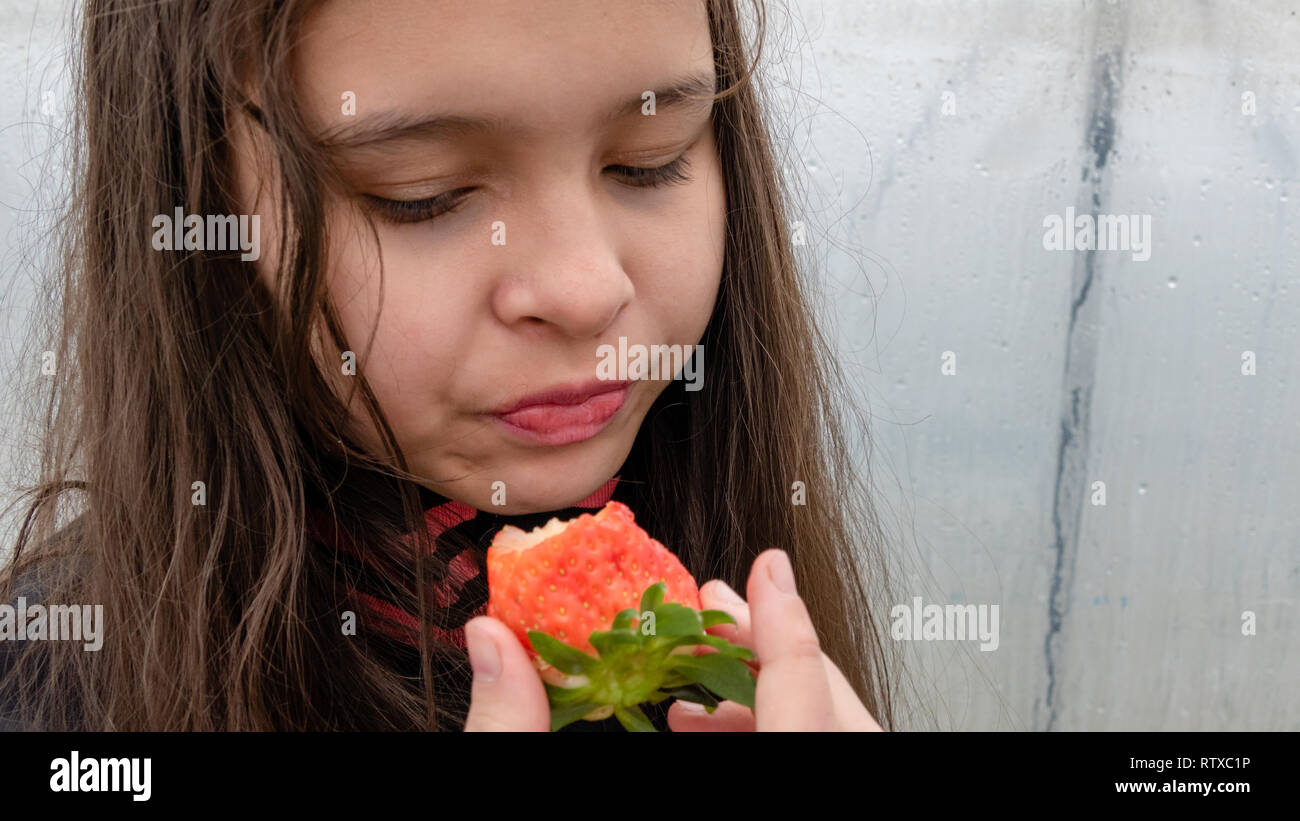 Mixed race Asian American tween girl eating strawberry Stock Photo - Alamy