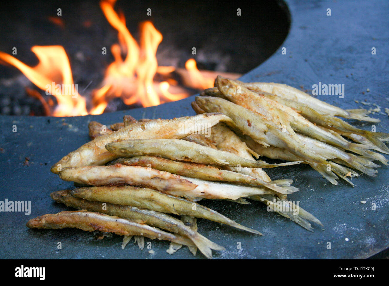 Traditional fried fish being cooked at the spring market in Vilnius ...