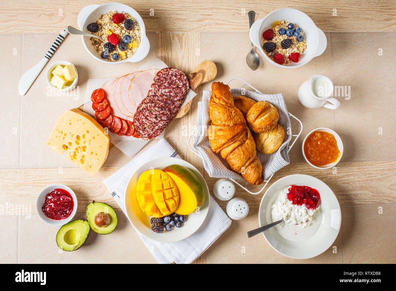 Continental breakfast table with croissants, jam, ham, butter, granola ...