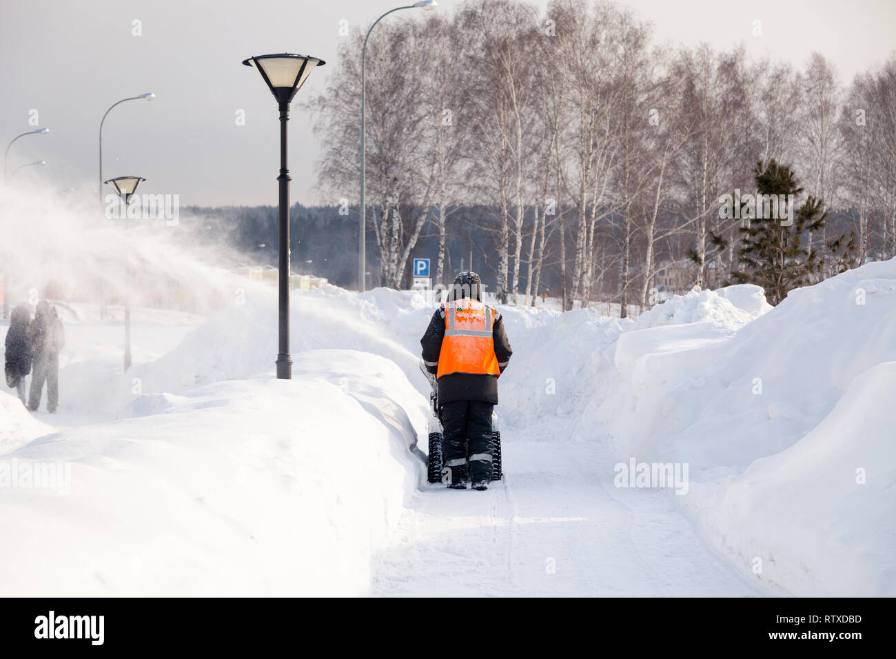 Russia Kemerovo 2019-02-22 Janitor in uniform orange vest cleans ...