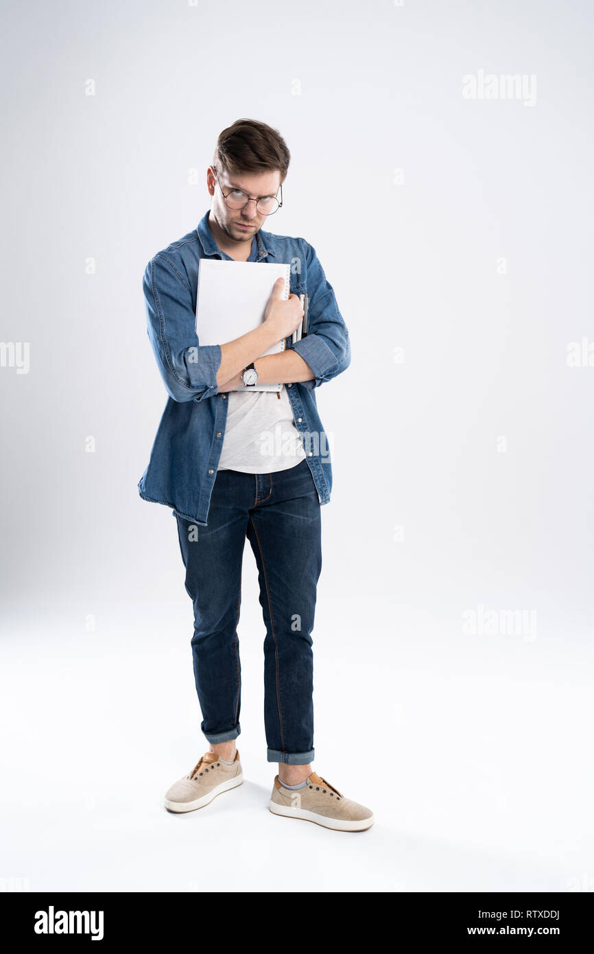 Happy young student standing full length with books and notes isolated ...