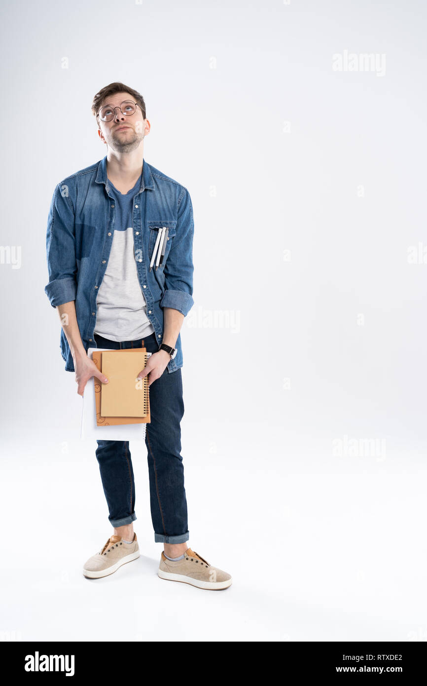 Happy young student standing full length with books and notes isolated ...