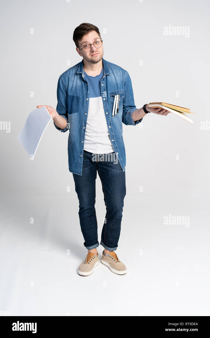 Happy young student standing full length with books and notes isolated ...
