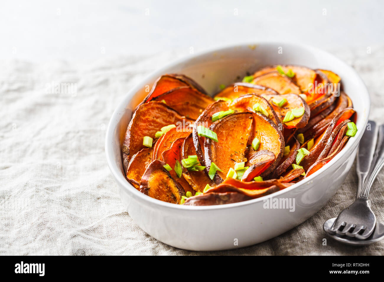 Baked sliced yam with green onions in white dish Stock Photo - Alamy