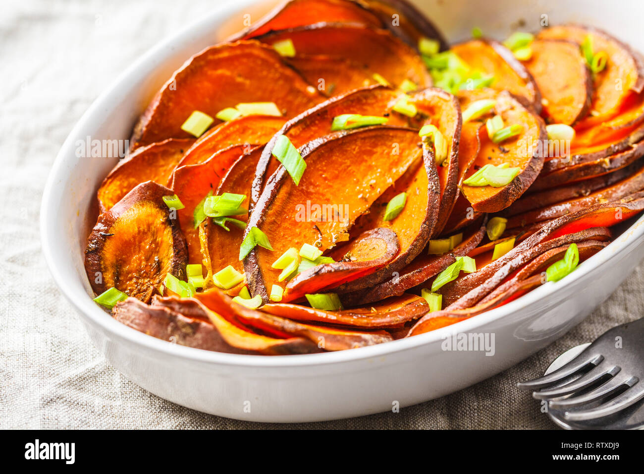 Baked sliced yam with green onions in white dish Stock Photo - Alamy