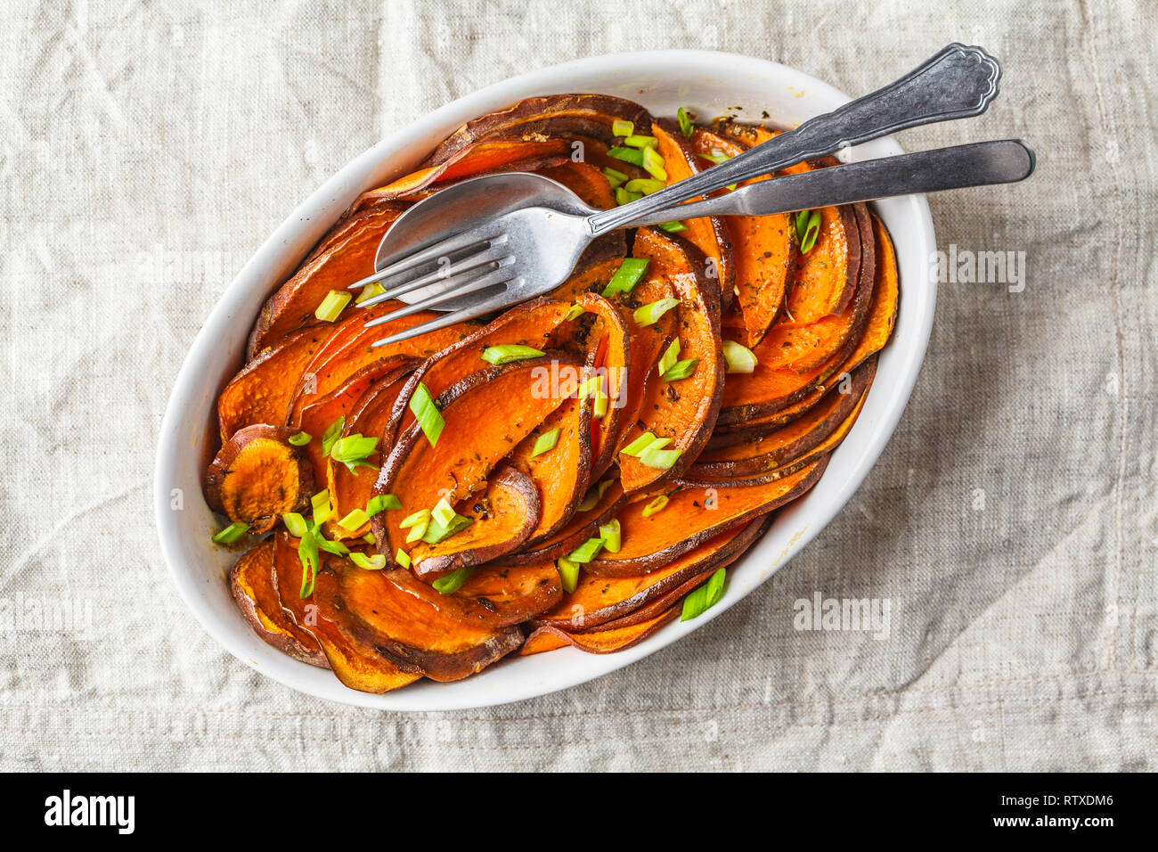 Baked sliced yam with green onions in white dish Stock Photo - Alamy