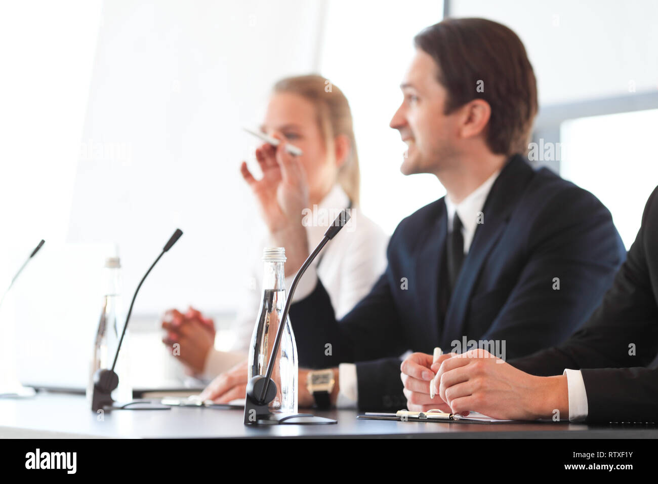 Group of speakers at business meeting at the table with microphones ...