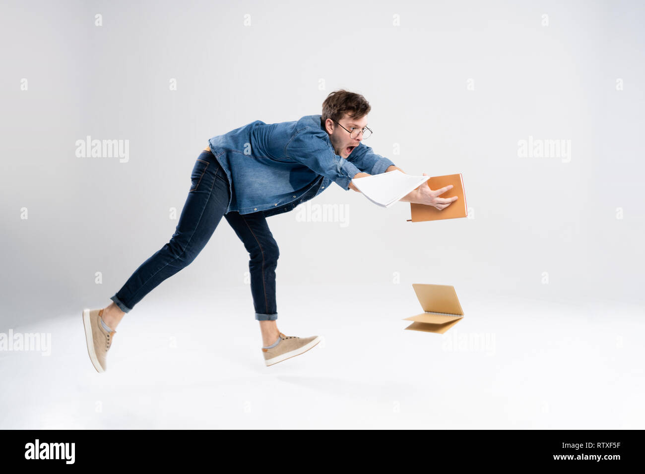 front view of going handsome man carries a stack of books. walking ...