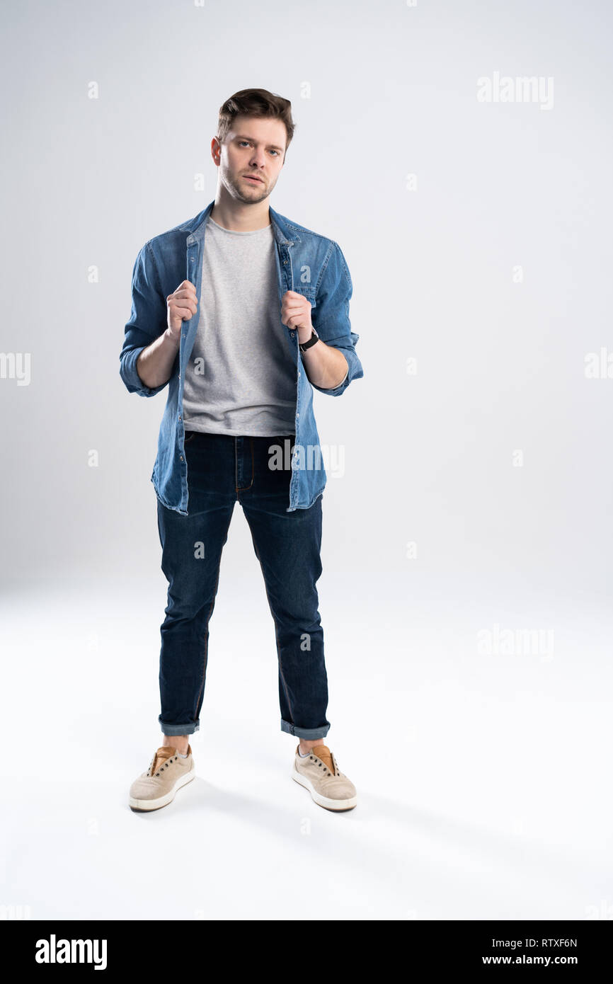 Full length portrait of a casual man standing over white background ...