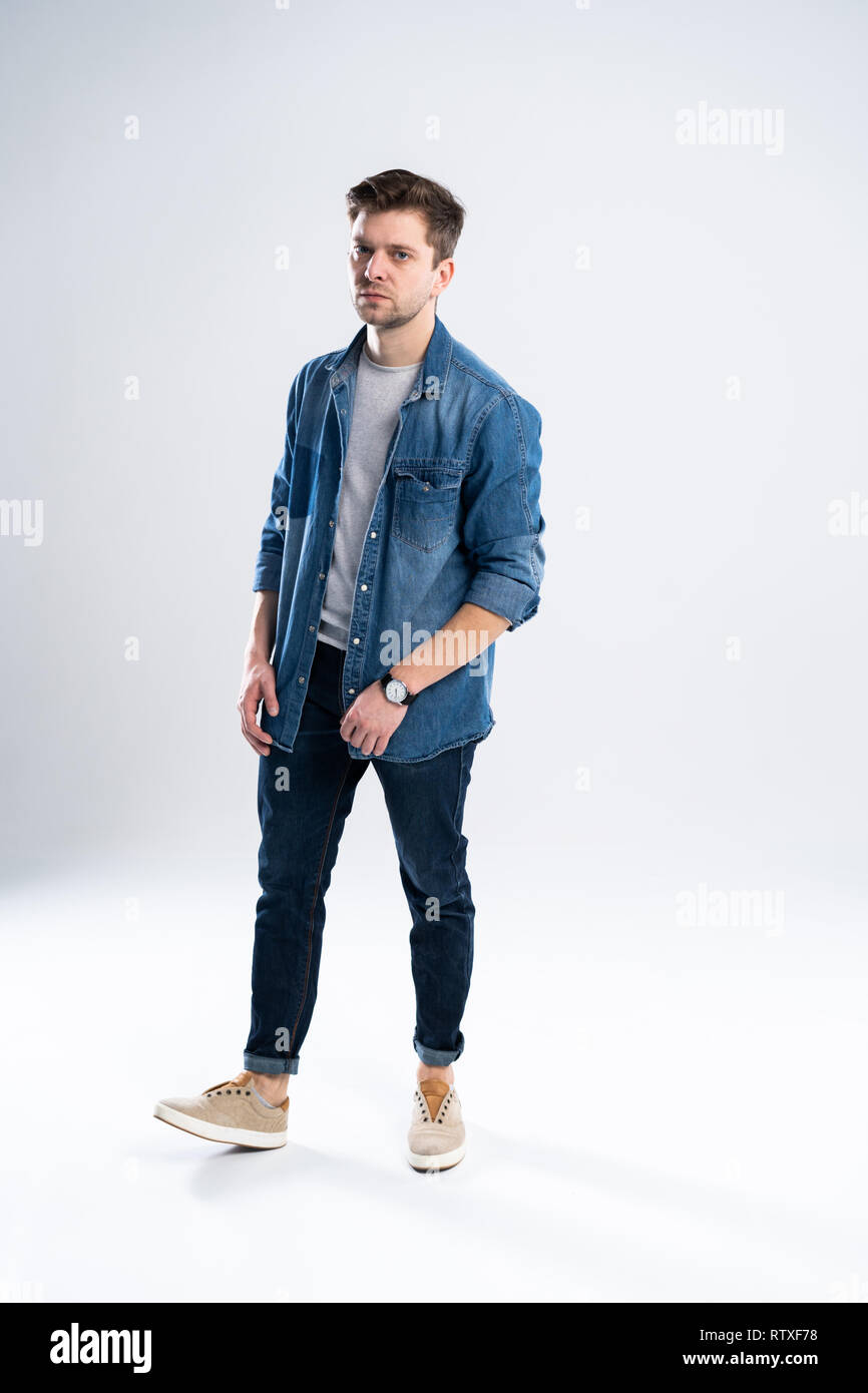 Full length portrait of a casual man standing over white background ...