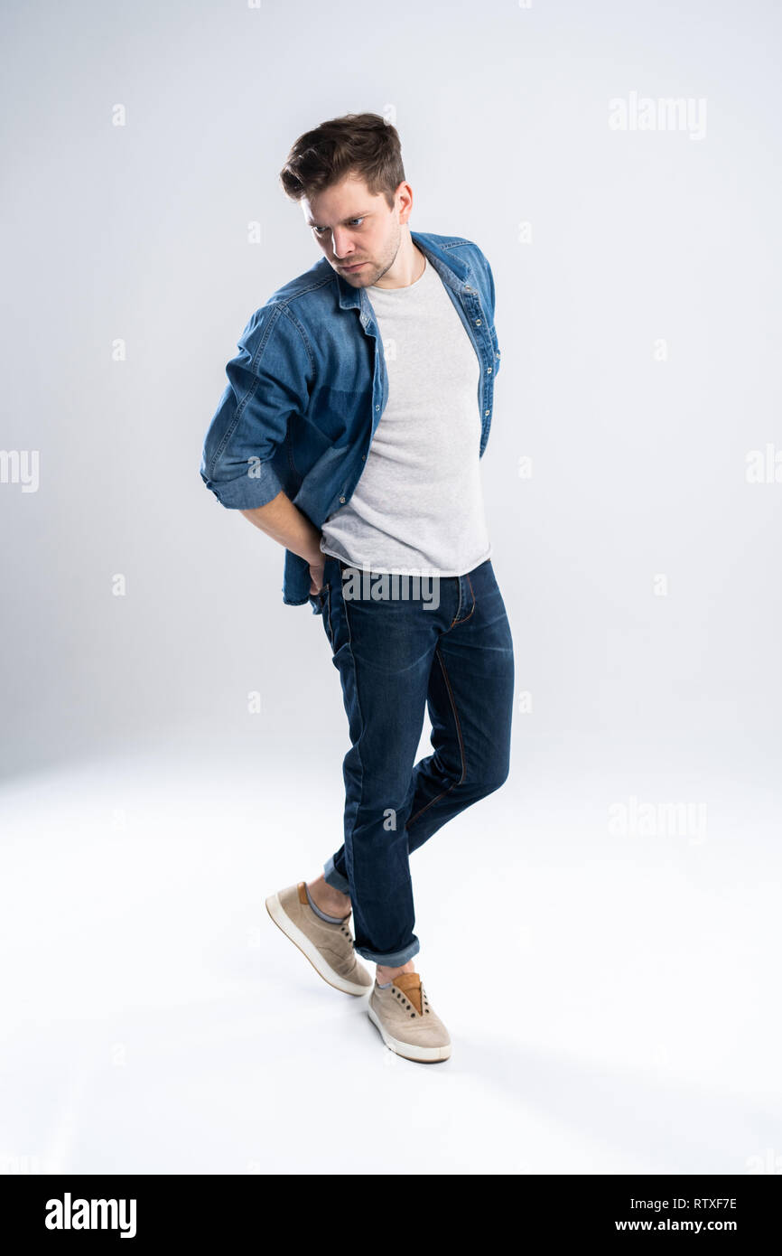 Full length portrait of a casual man standing over white background ...