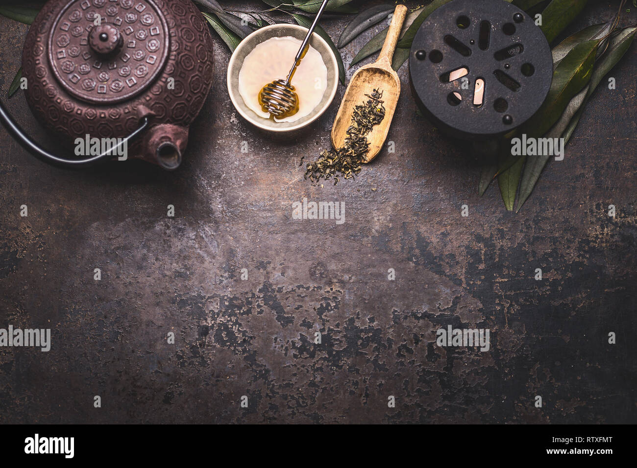 Traditional Asian green tea background with black iron teapot, candle ...