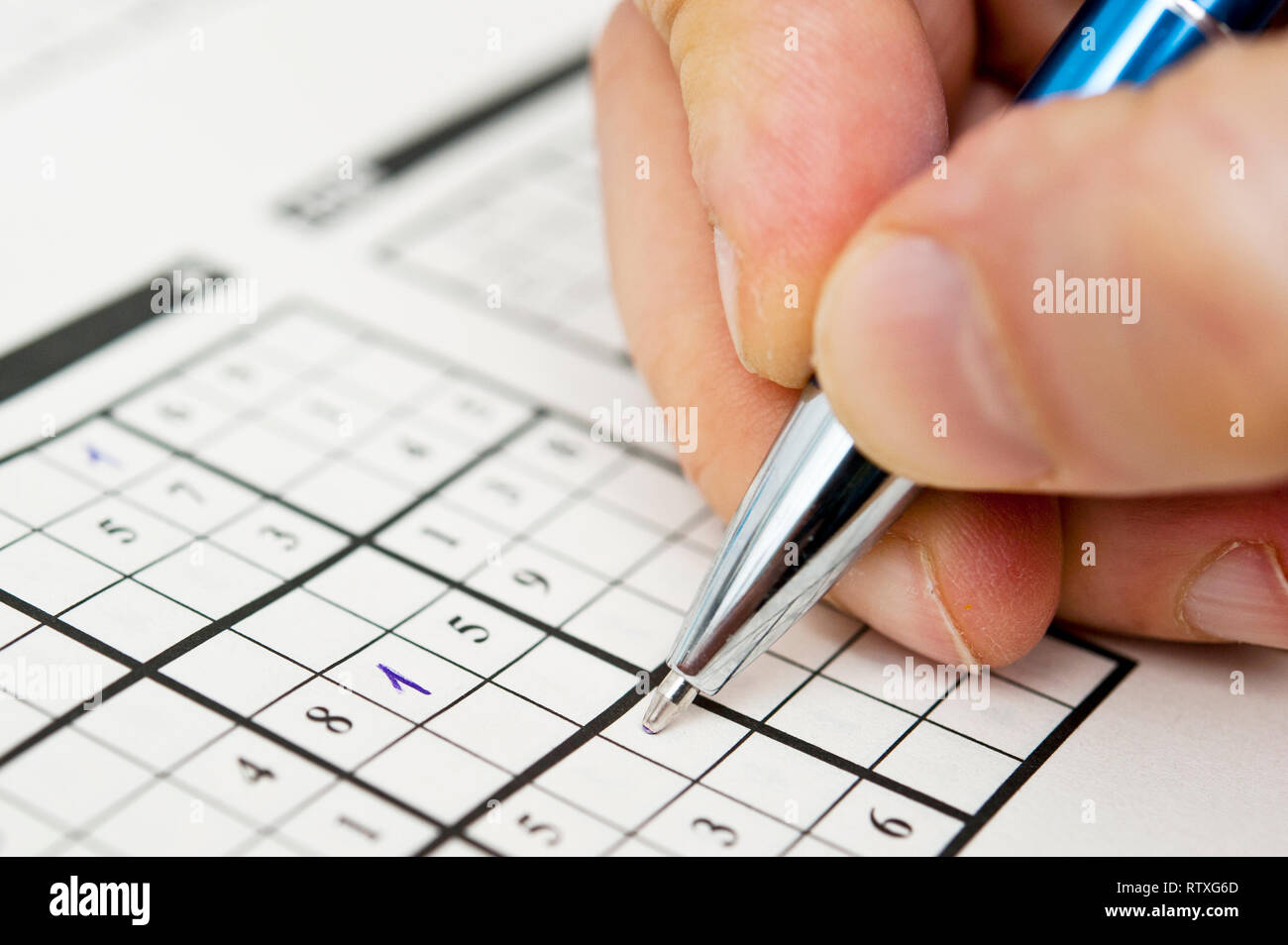 hand of a man solving a Sudoku puzzle Stock Photo - Alamy