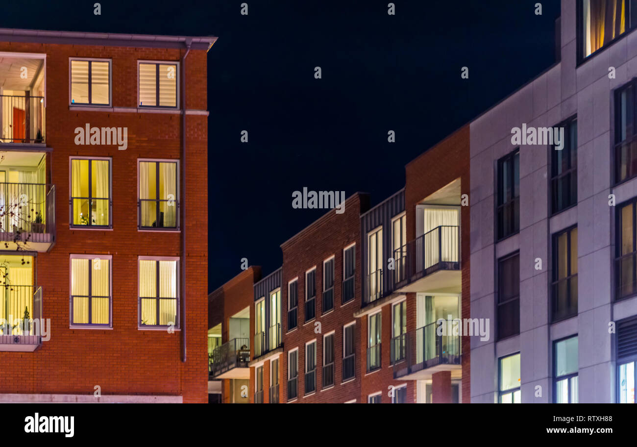 Modern dutch apartment buildings with balconies, lighted windows by ...