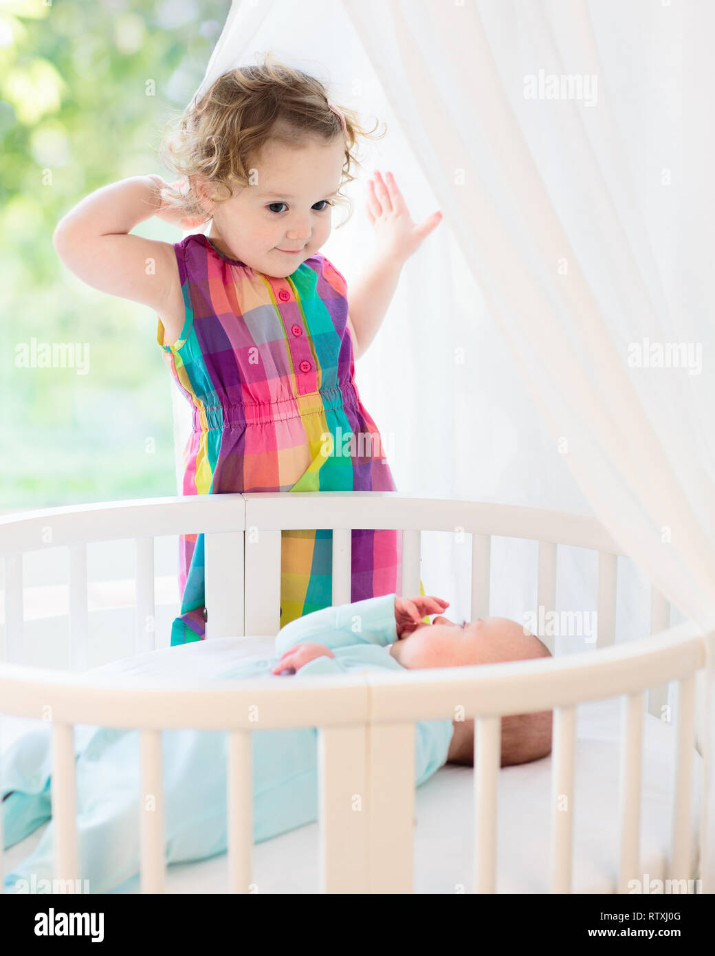 Sister and baby brother. Little girl meeting newborn sibling. Kids in ...