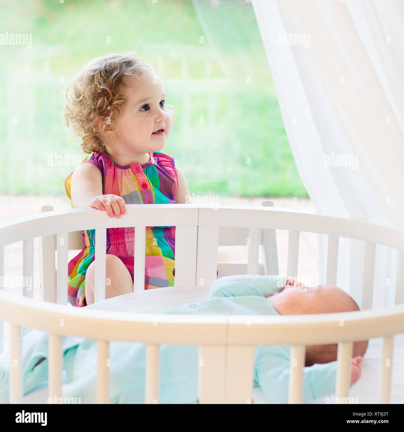 Sister and baby brother. Little girl meeting newborn sibling. Kids in ...