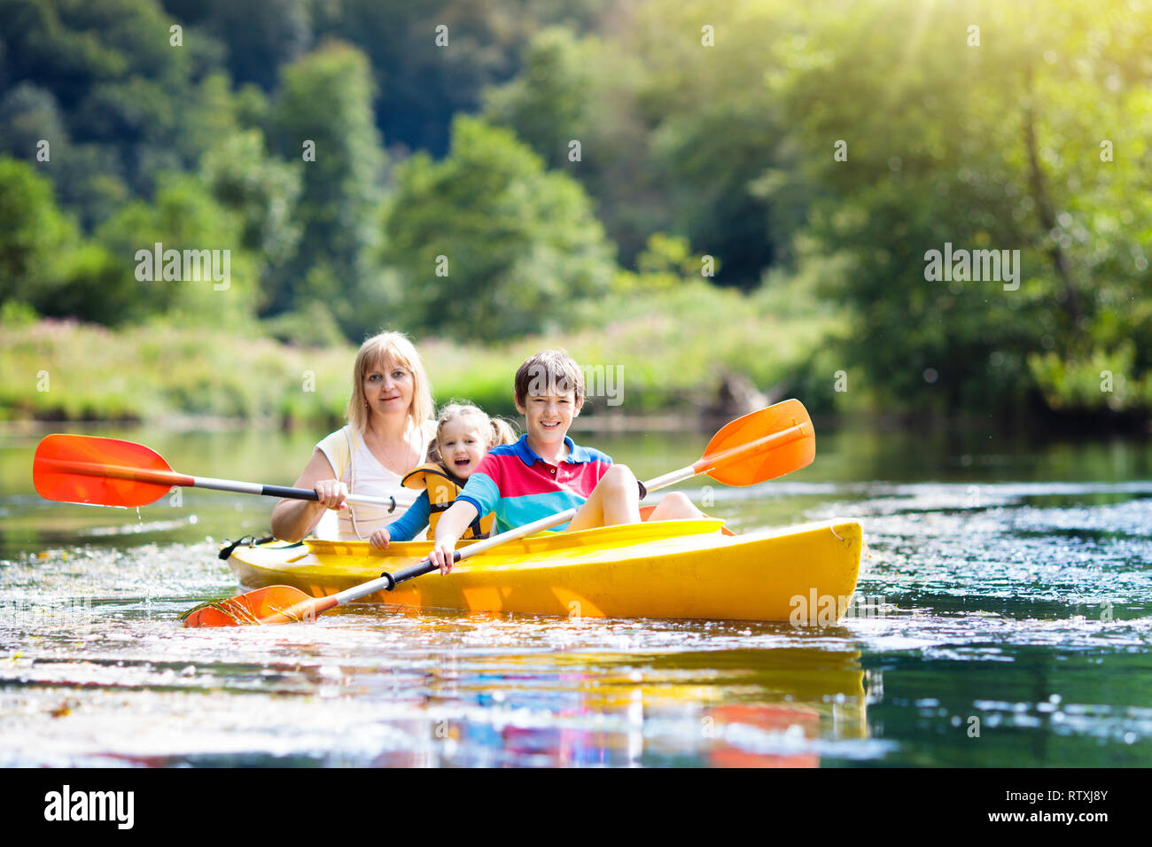 Child with paddle on kayak. Summer camp for kids. Kayaking and canoeing ...