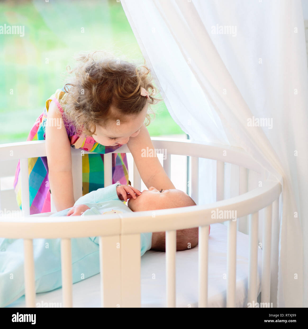 Sister and baby brother. Little girl meeting newborn sibling. Kids in ...