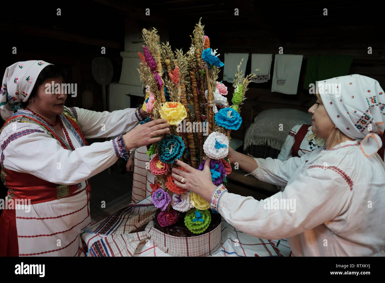 Belarusian women in traditional garment decorating a traditional ...
