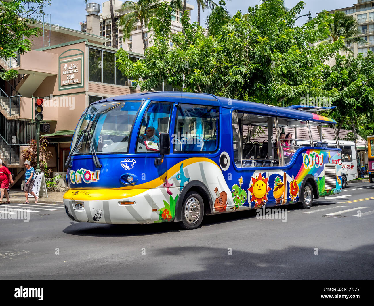 Colorful tourist bus on Kalakaua avenue in Waikiki on April 29, 2014 ...