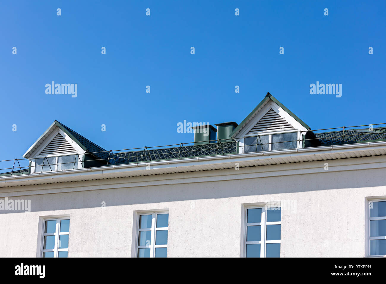 house roof with new rain gutter system against blue sky background ...