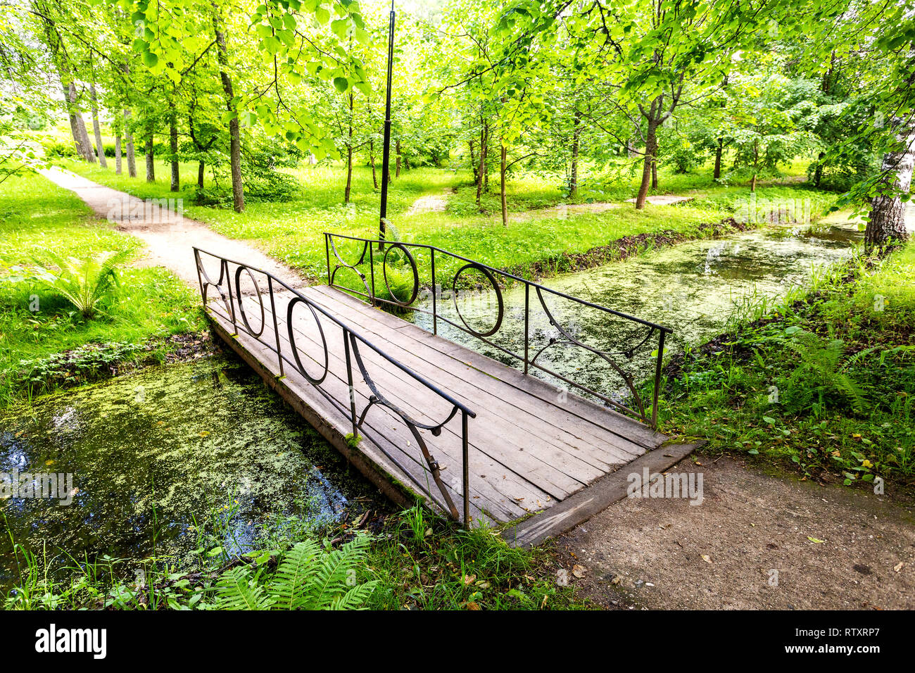 Small wooden bridge with forged railings at the summer park Stock Photo ...