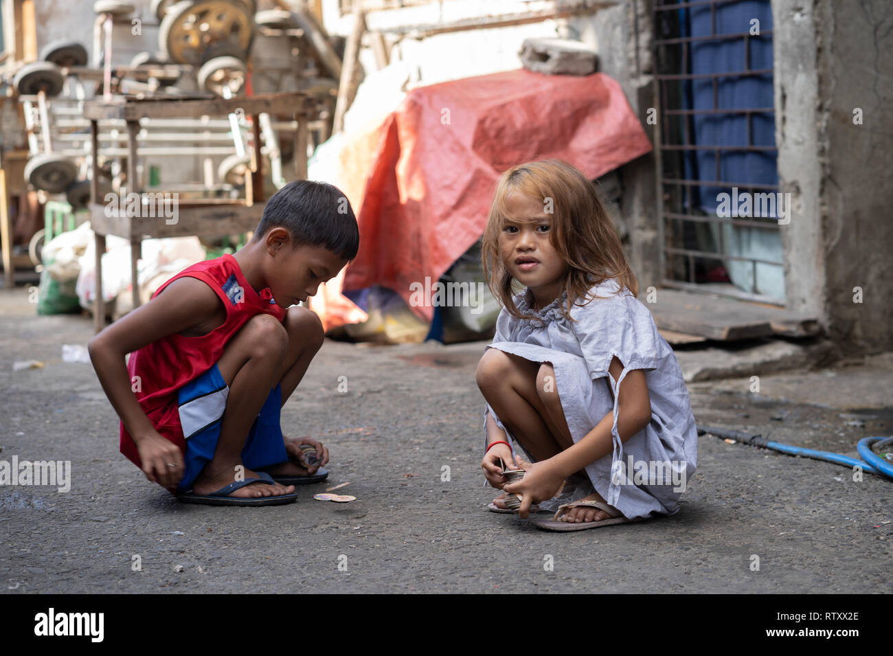 Two young Filipino children play a game within a slum area of Cebu City ...