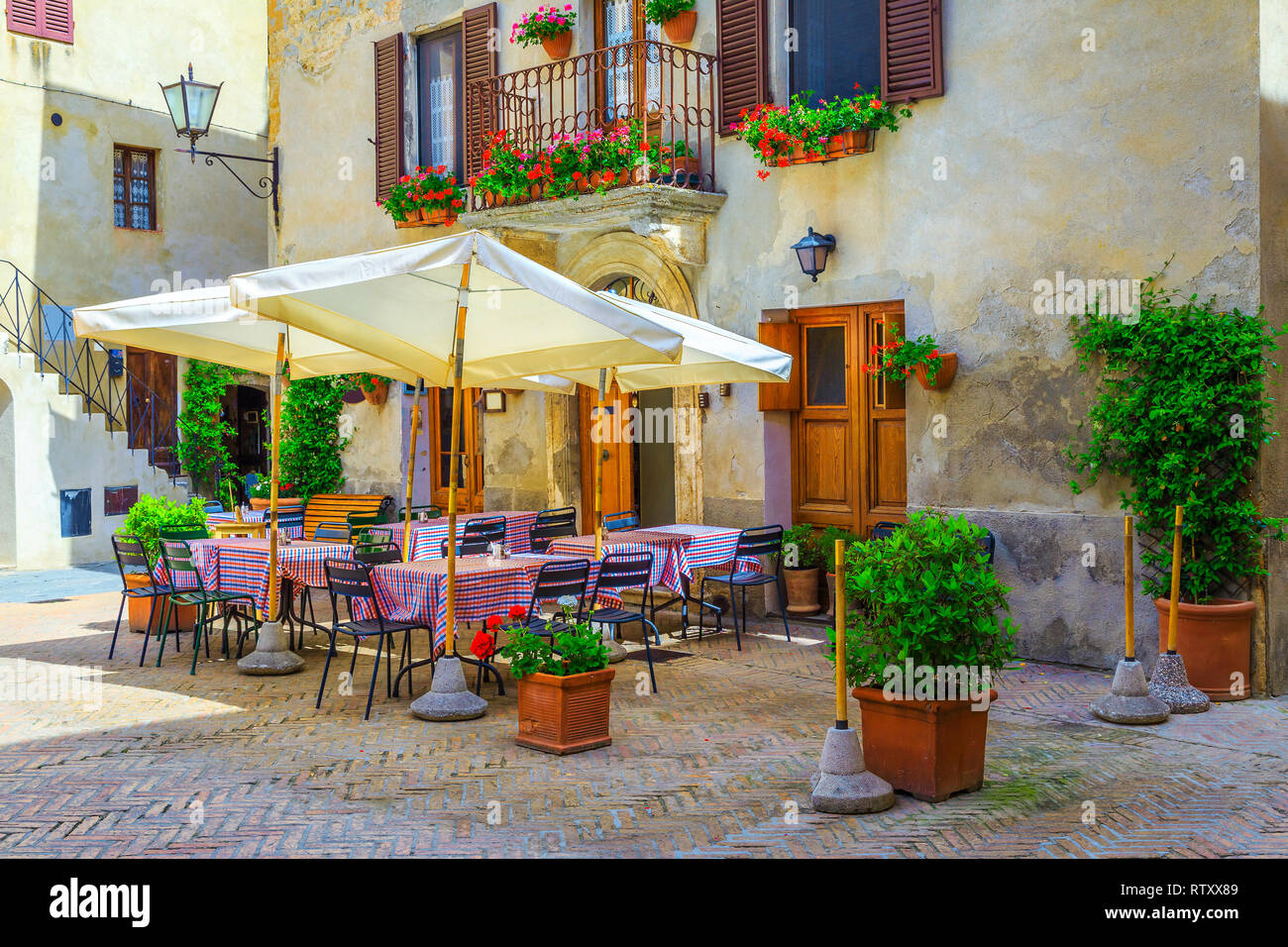Cozy street cafe and restaurant decorated with colorful flowers, Pienza ...