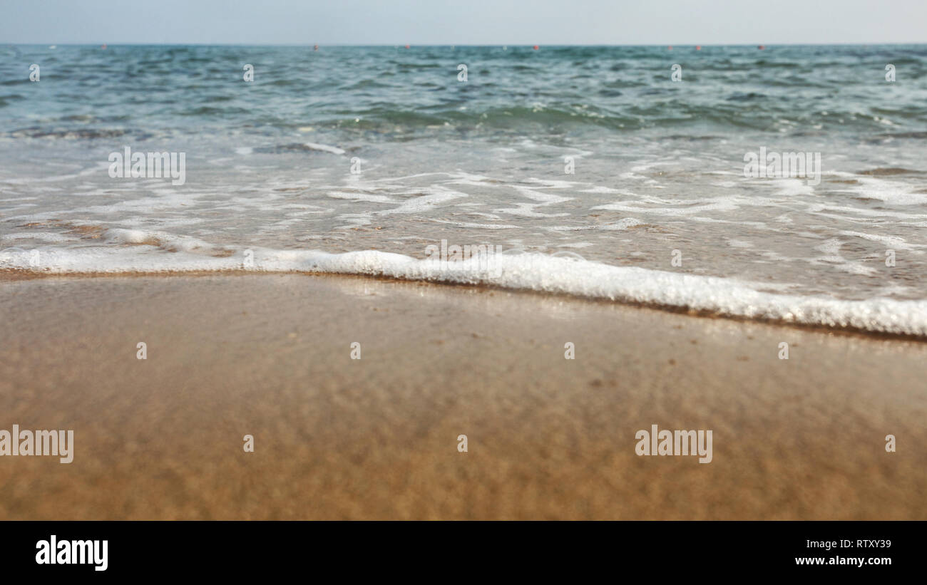 Low angle / ground level photo of wet sand on the beach, sea in ...