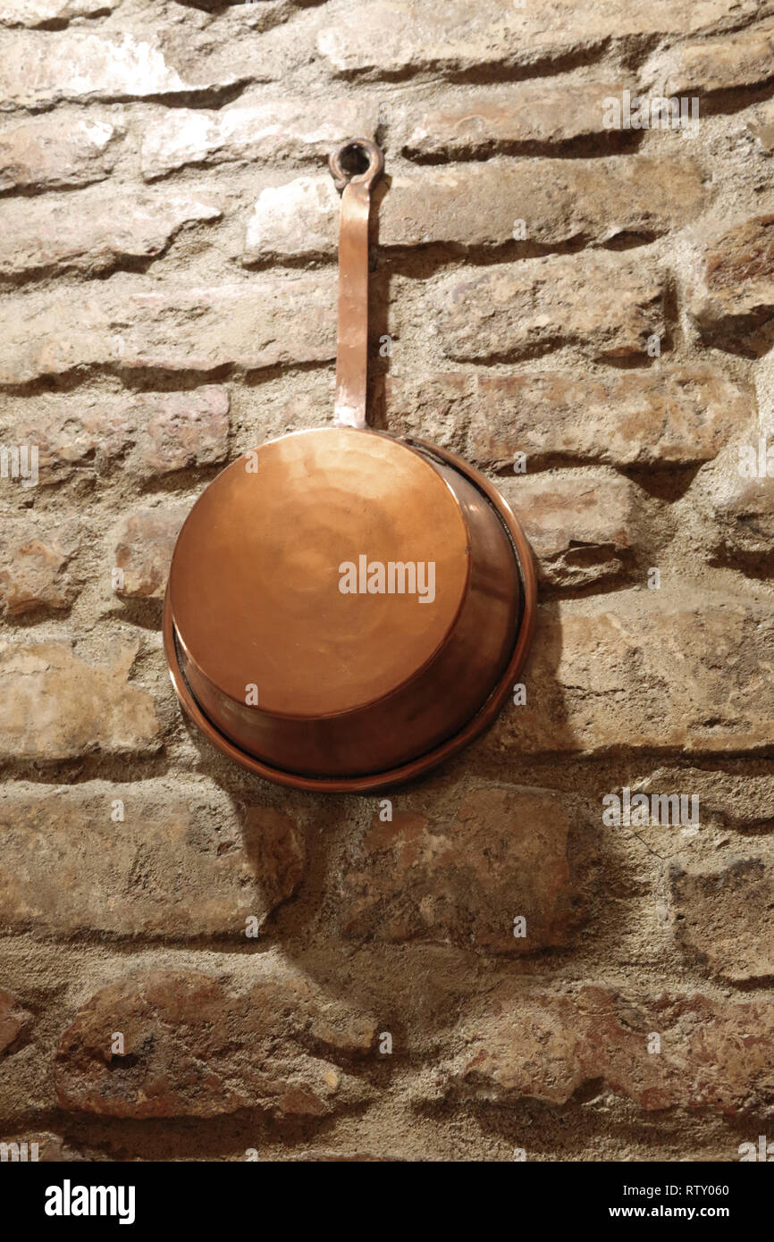 antique copper cookware on a brick wall Stock Photo - Alamy