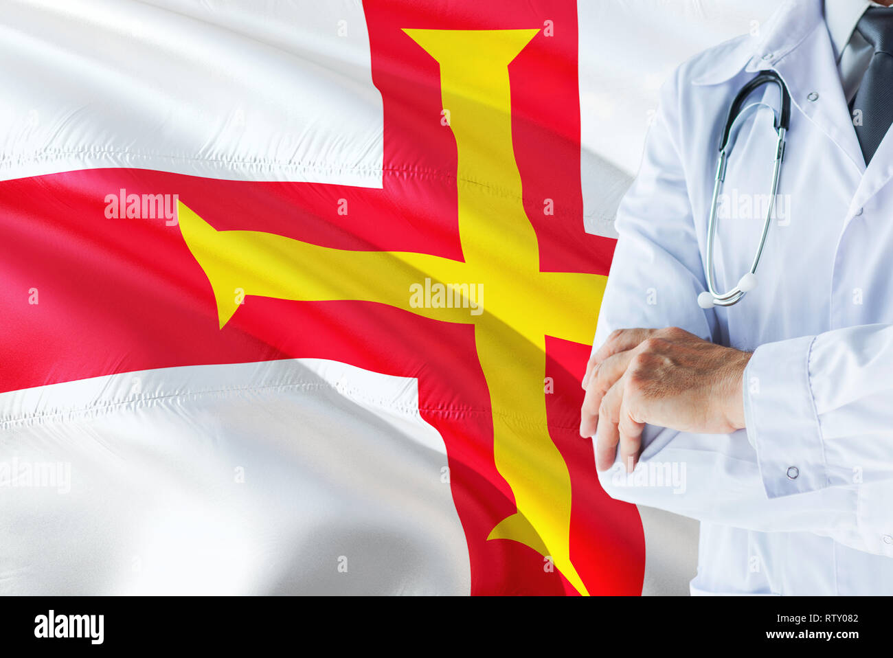 Doctor standing with stethoscope on Guernsey flag background. National ...