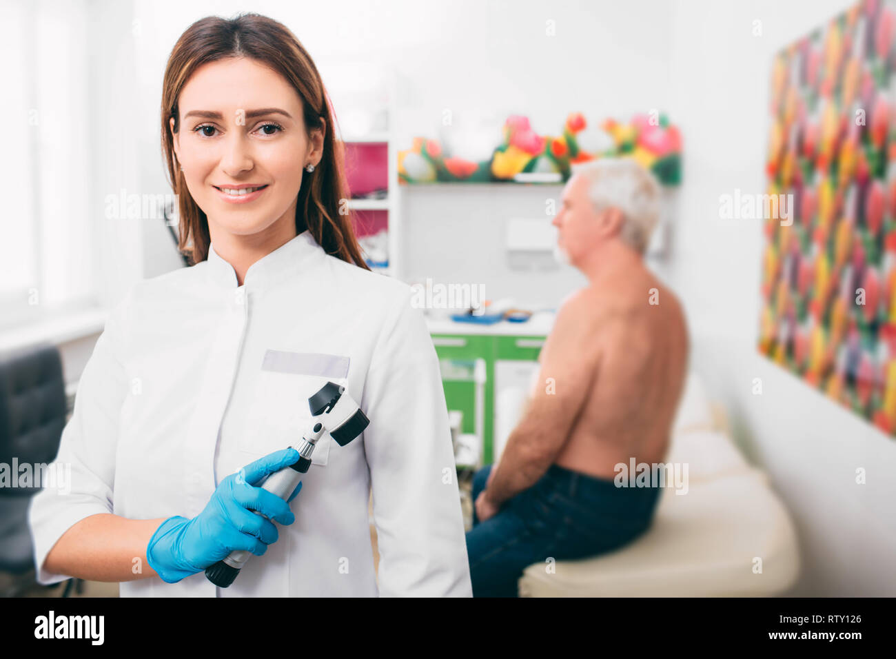 doctor dermatologist with dermatoscope, smiling while looking at camera ...