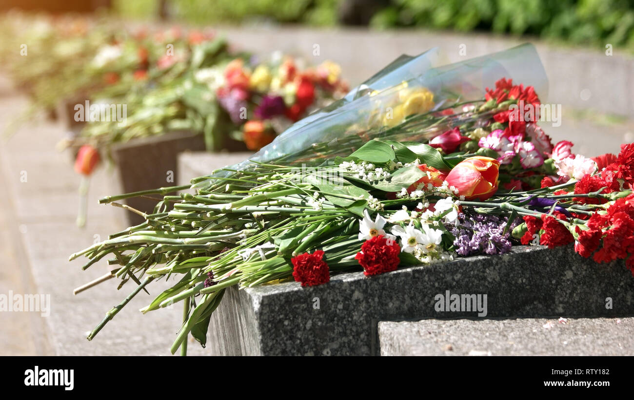 Victory Day fresh flowers close up. Flowers on granite monument. Symbol ...