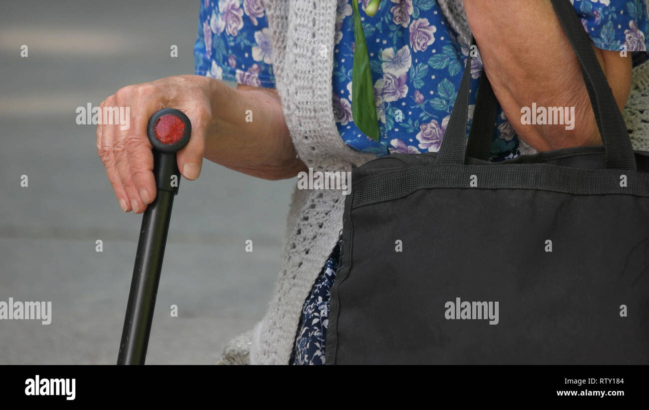 Old woman hand holding a walking cane. Close up hand of elderly woman ...
