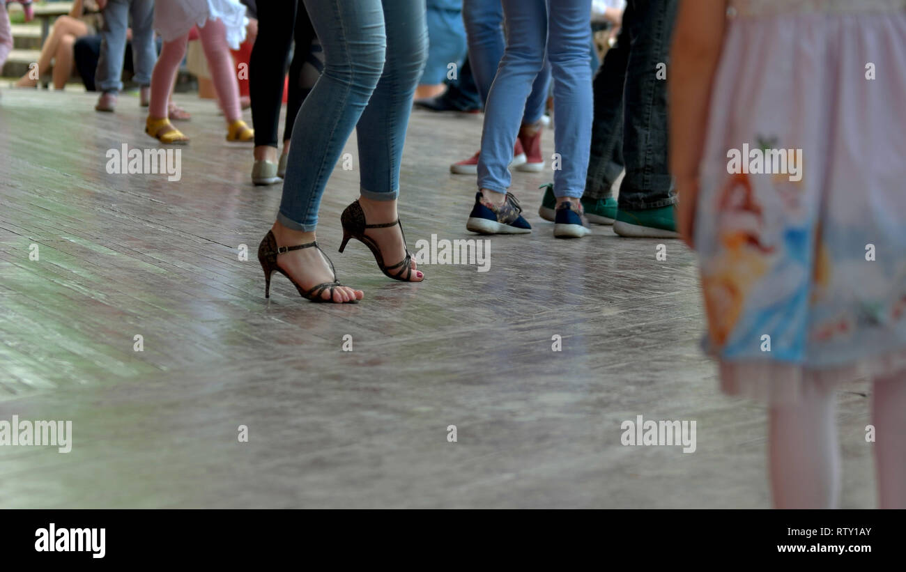 Legs of people in active dance. Young woman dancing on party, cropped ...